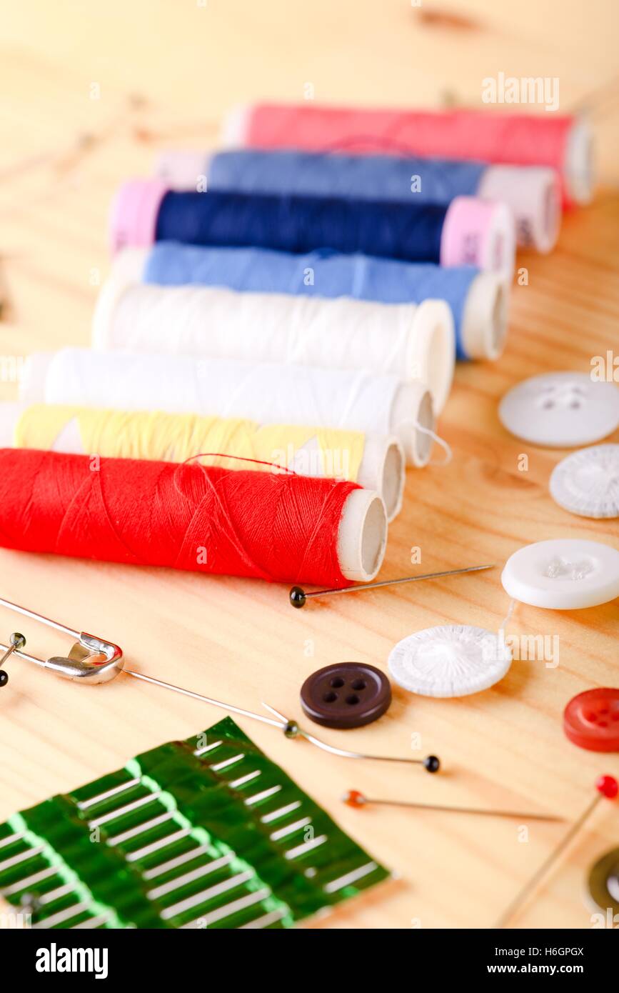 Vertical photo with several sewing accessories as buttons, measuring ...