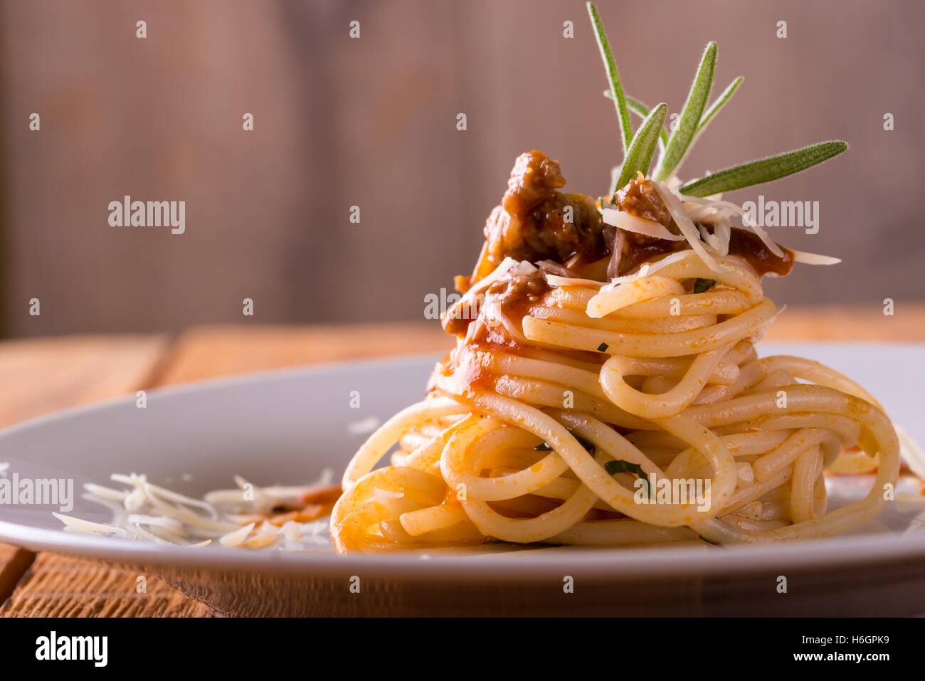 Horizontal photo of single spaghetti portion. Few pieces of minced meat ...