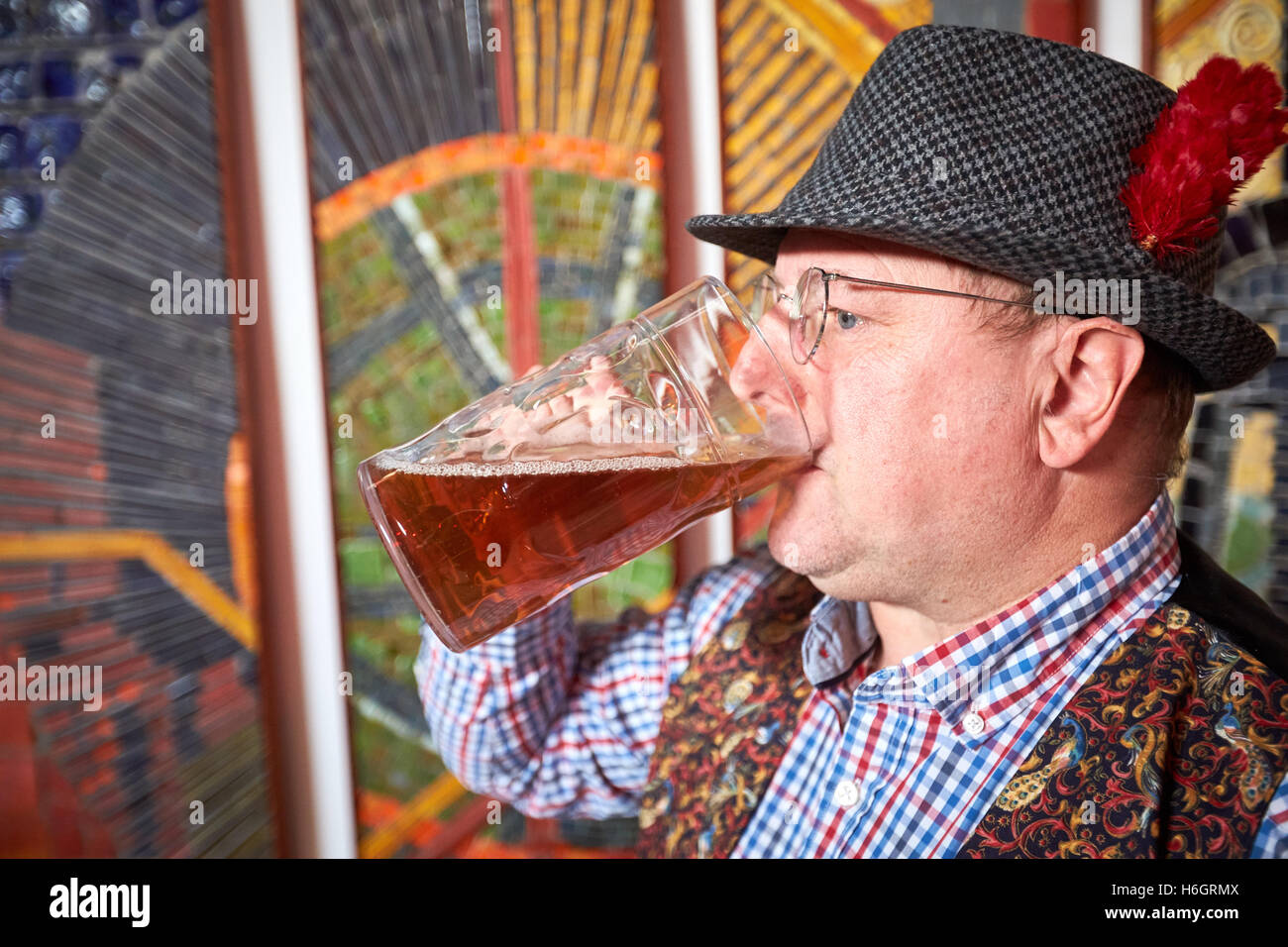 Man drinking beer from a stein during an Oktoberfest event Stock Photo ...