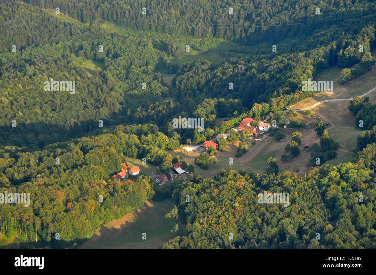 Aerial view of small Slovenian village amidst forest Stock Photo - Alamy