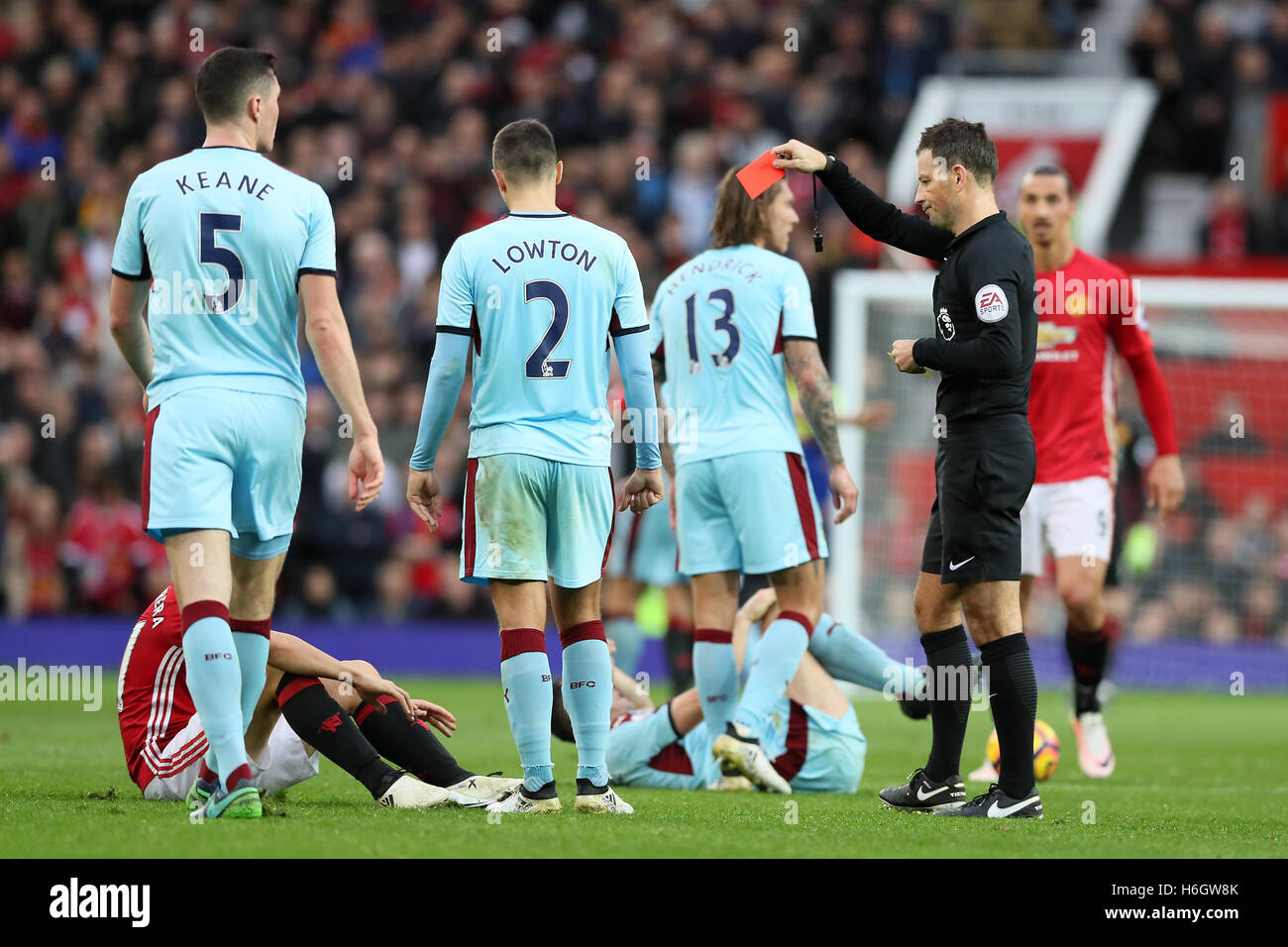 Referee Mark Clattenburg (right) shows Manchester United's Ander Herrera (left, floor) a red ...