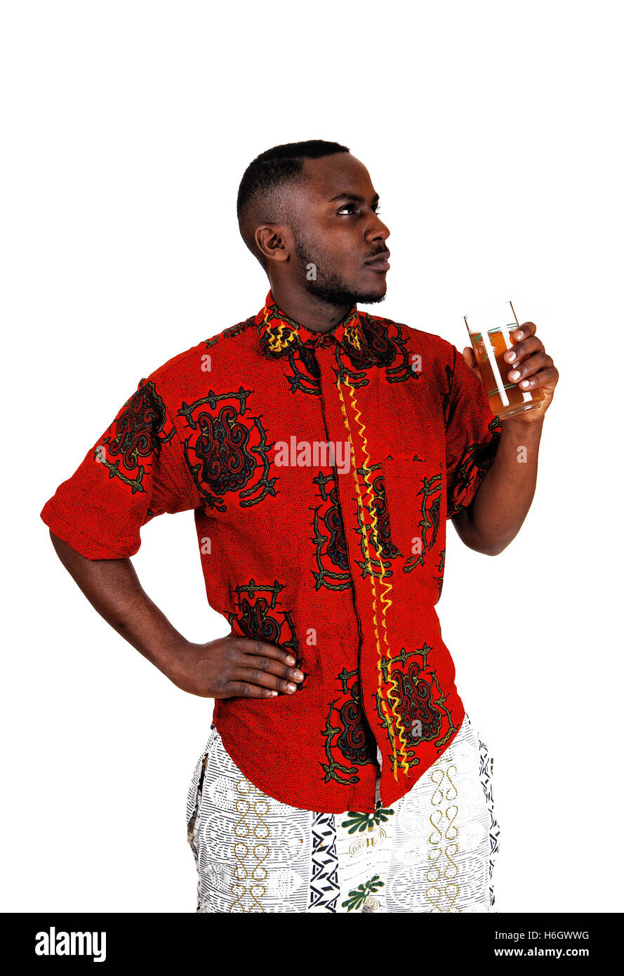 A handsome young black man standing for white background with a glass ...