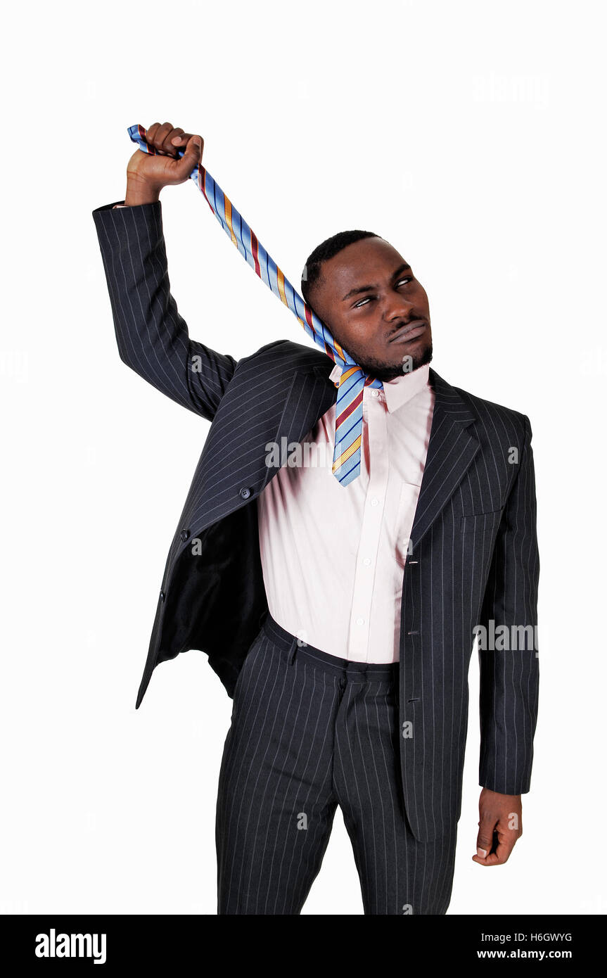 A serious young black businessman pulling on his necktie, in a suit for ...
