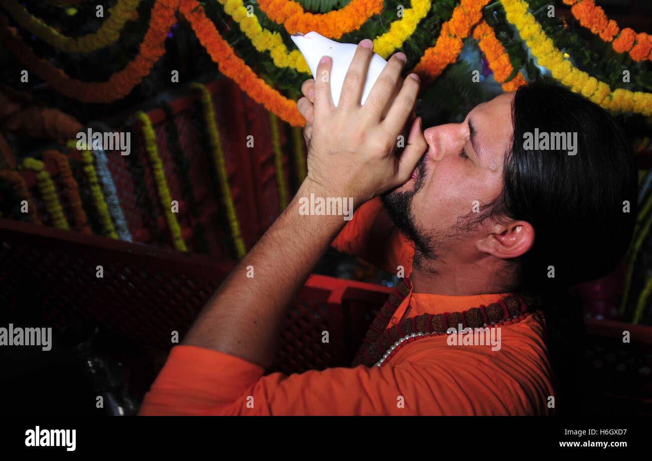 Allahabad, India. 29th Oct, 2016. A Hindu priest playing conch shell ...