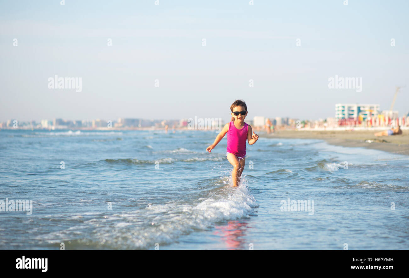 Cute child running in the waves Stock Photo - Alamy