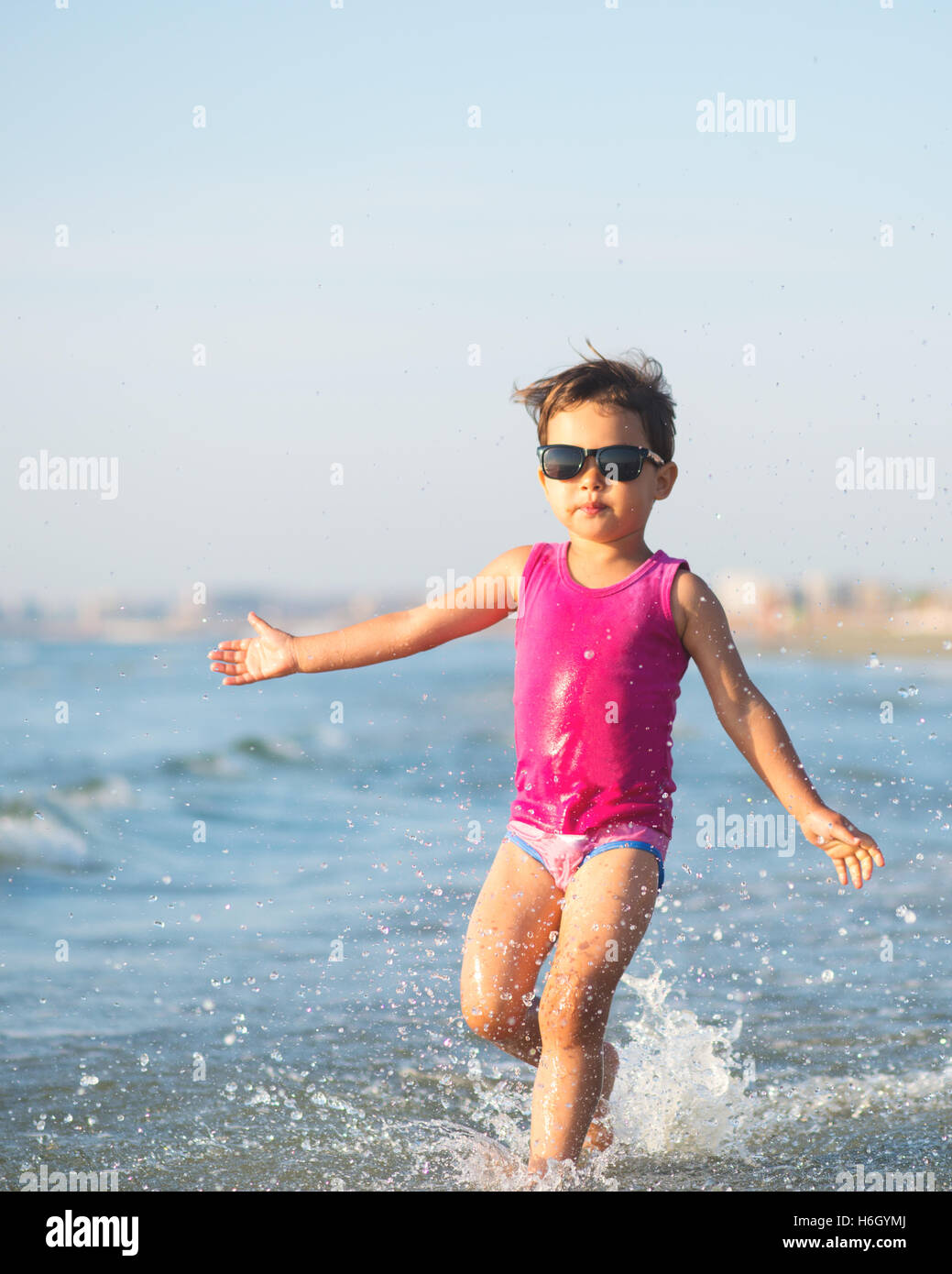 Cute child running in the waves Stock Photo - Alamy
