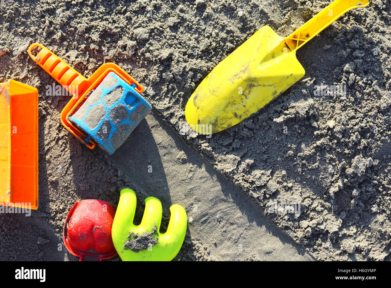Children's toys on sand Stock Photo - Alamy