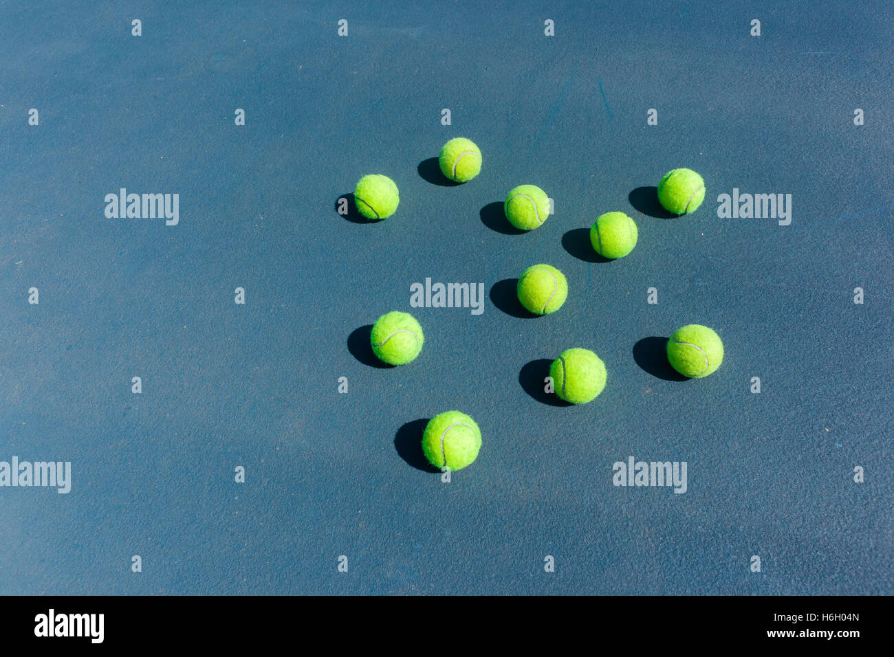 Tennis balls on blue playing court surface closeup Stock Photo - Alamy