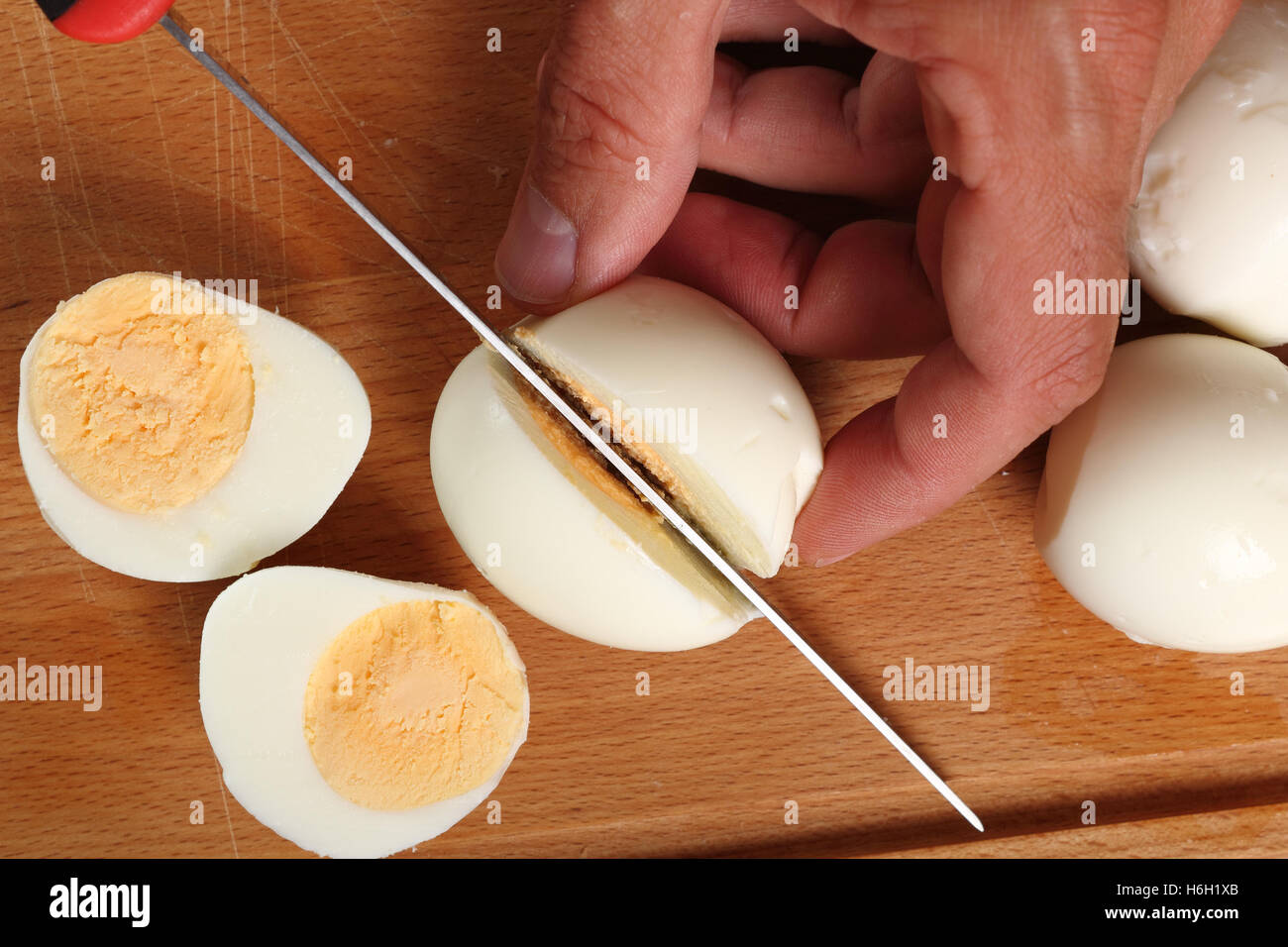 Slicing hard boiled eggs in half Stock Photo - Alamy
