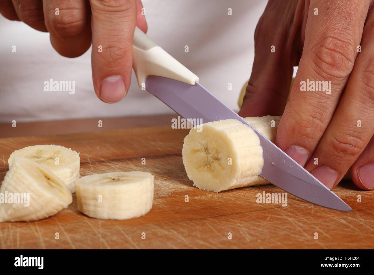 Slicing peeled banana Stock Photo - Alamy
