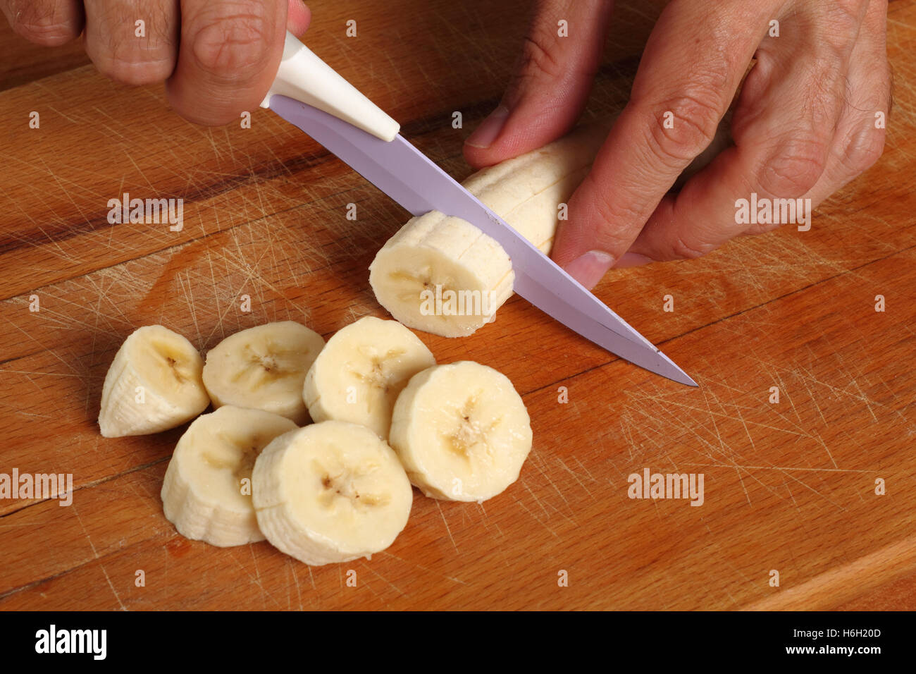 Slicing peeled banana Stock Photo - Alamy