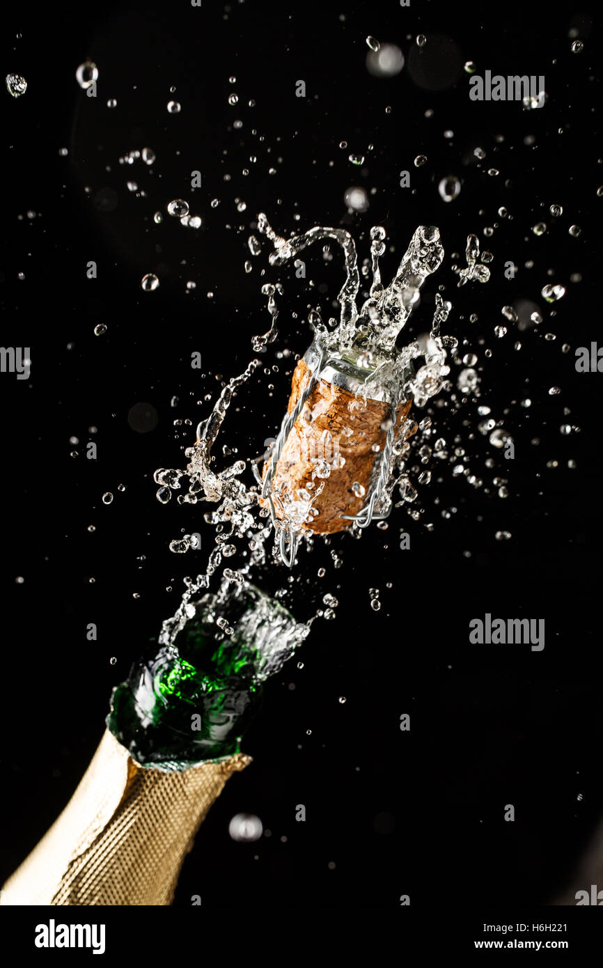 Champagne closeup from exploding bottles on a black background. Party ...
