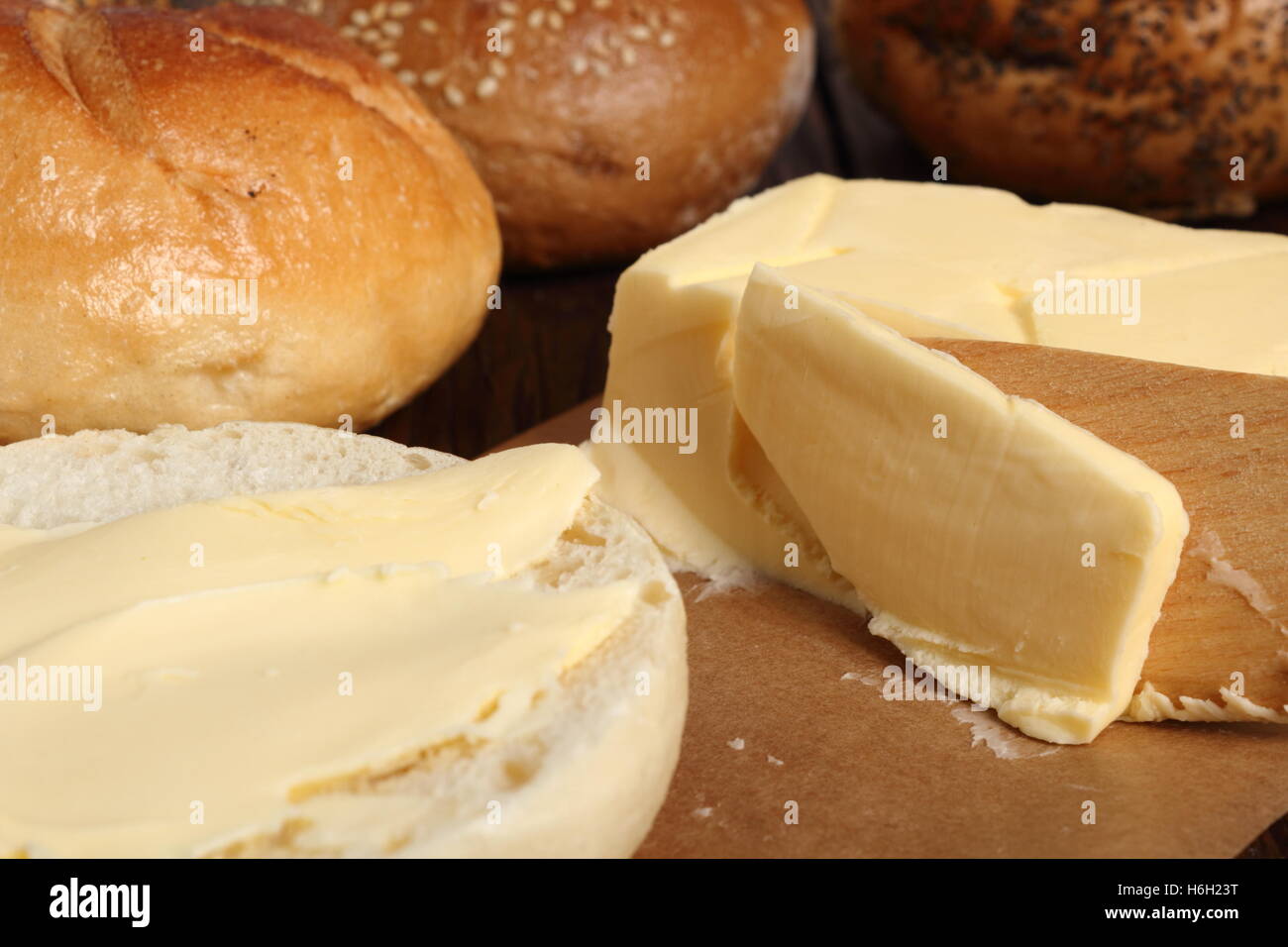 Spreading butter on bread roll Stock Photo - Alamy