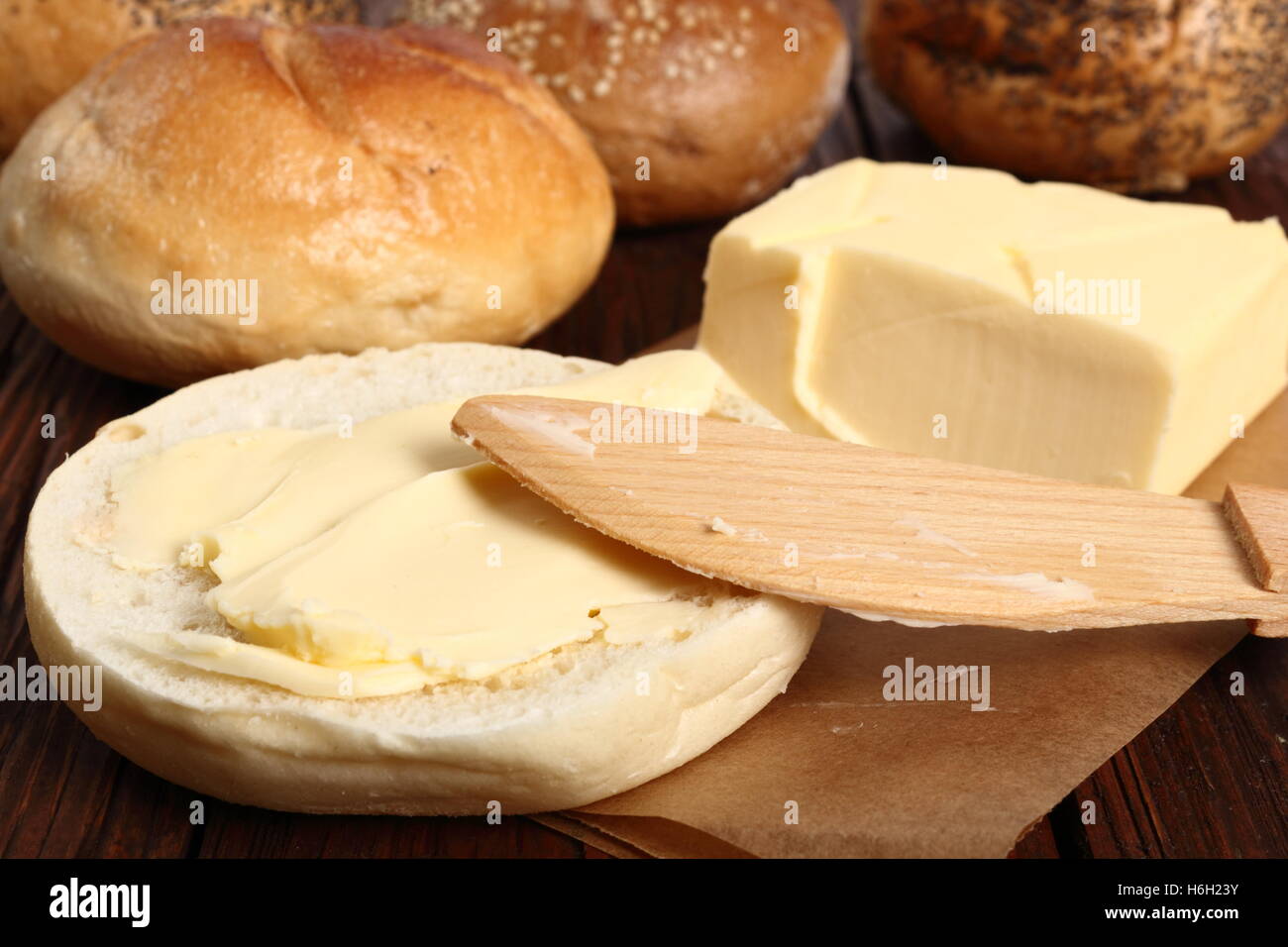 Spreading butter on bread roll Stock Photo - Alamy