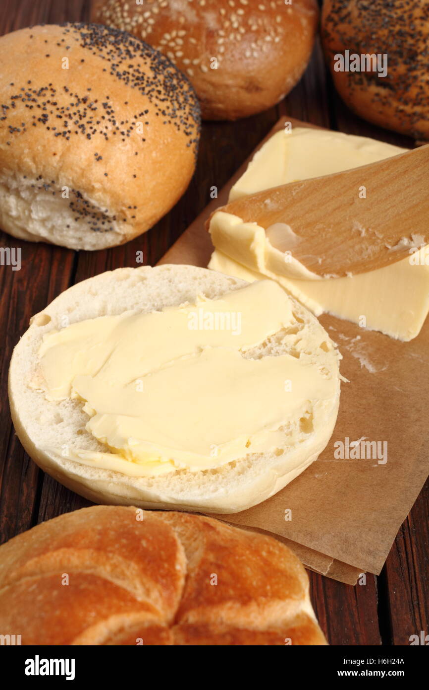 Spreading butter on bread roll Stock Photo - Alamy