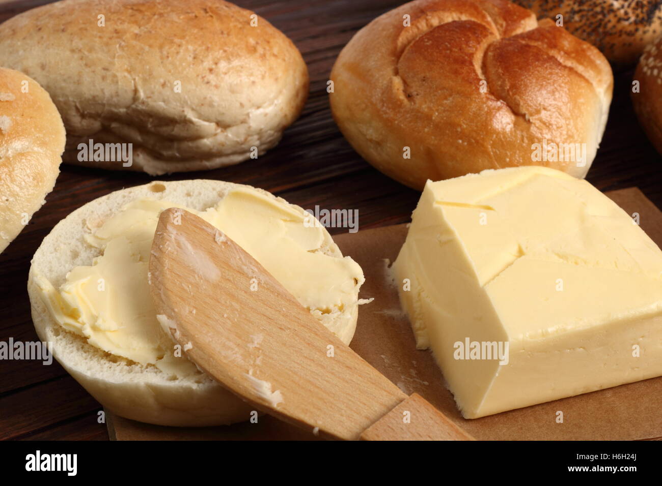 Spreading butter on bread roll Stock Photo - Alamy