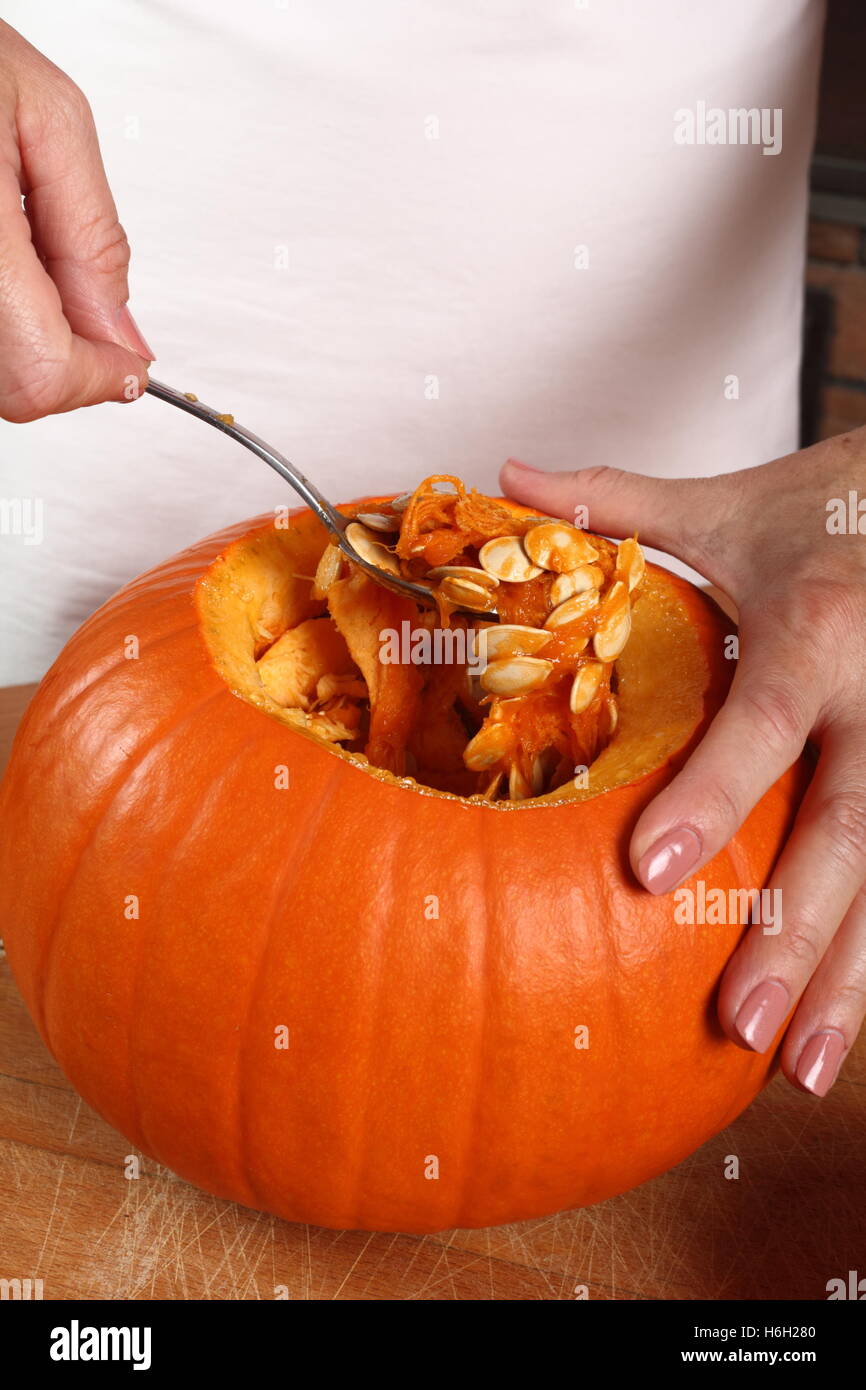 Making Jack o lantern. Scooping out the pumpkin Stock Photo - Alamy