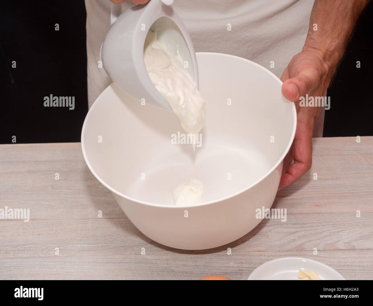 Adding Yogurt into bowl. Making Yogurt Cake Stock Photo - Alamy