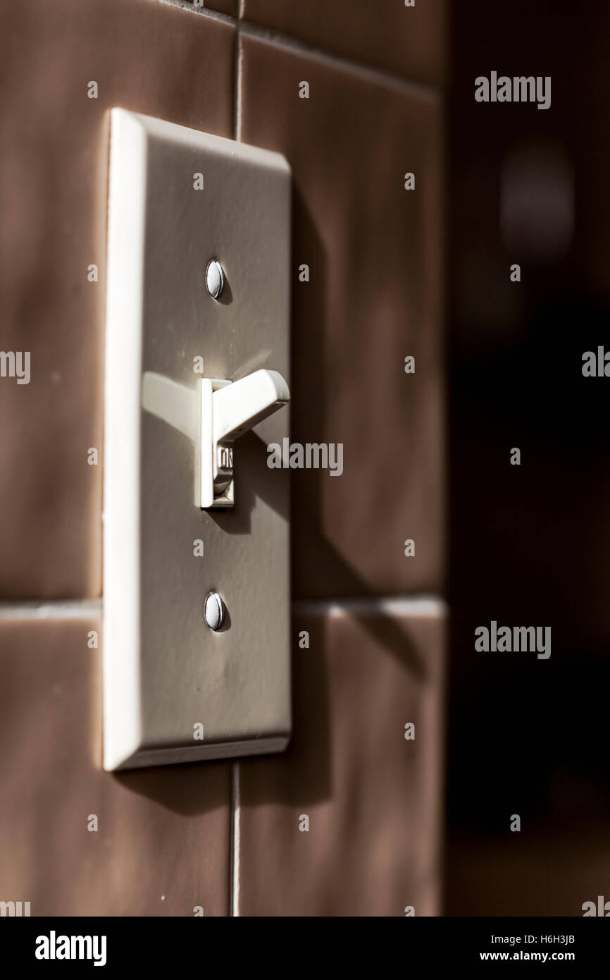 Light switch on tile ceramics wall turned on Stock Photo - Alamy
