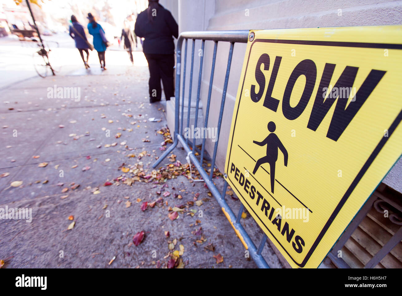 Warning sign saying "Slow - Pedestrians" on a portable barrier in the ...