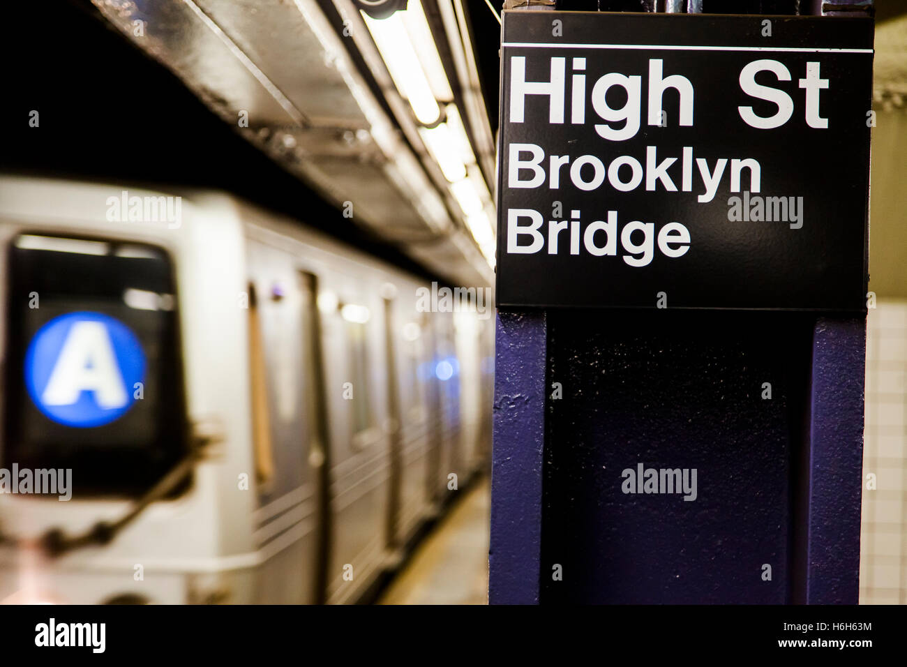 Subway train approaching behind the sign depicting it's the High St ...