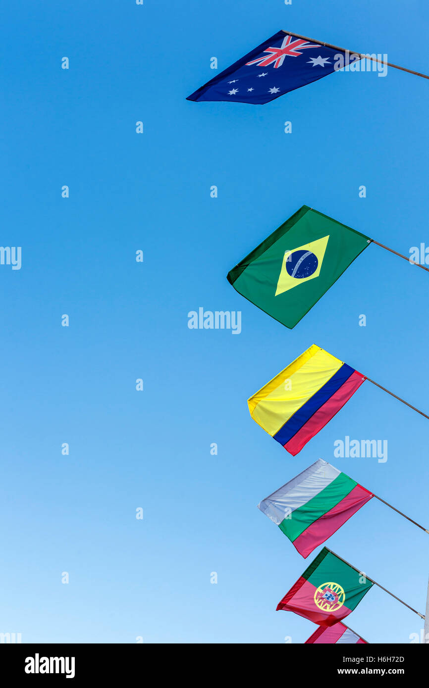 A row of many national flags of various nations fluttering in the wind ...