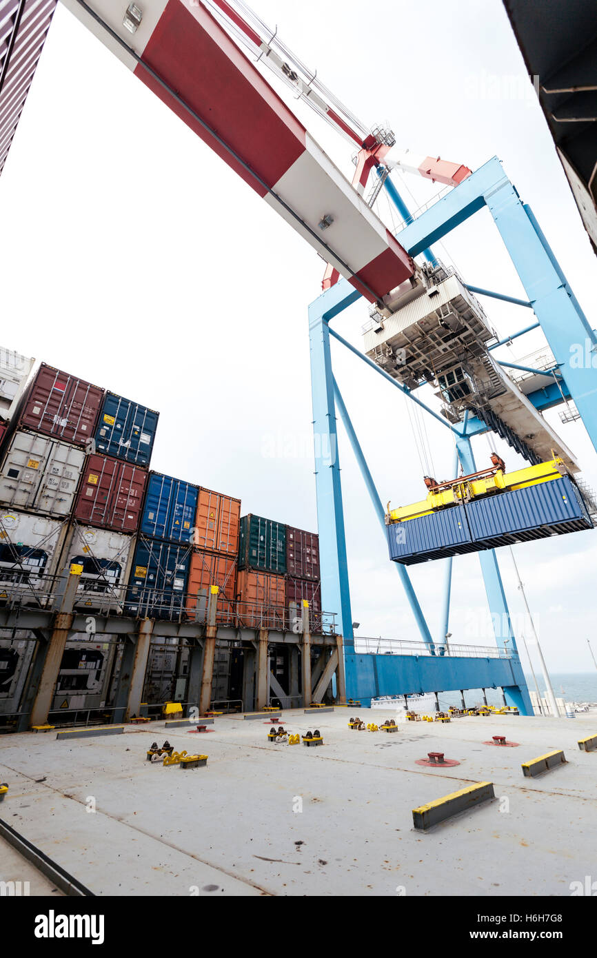 View of a freighter ship being loaded by a crane with containers at a ...