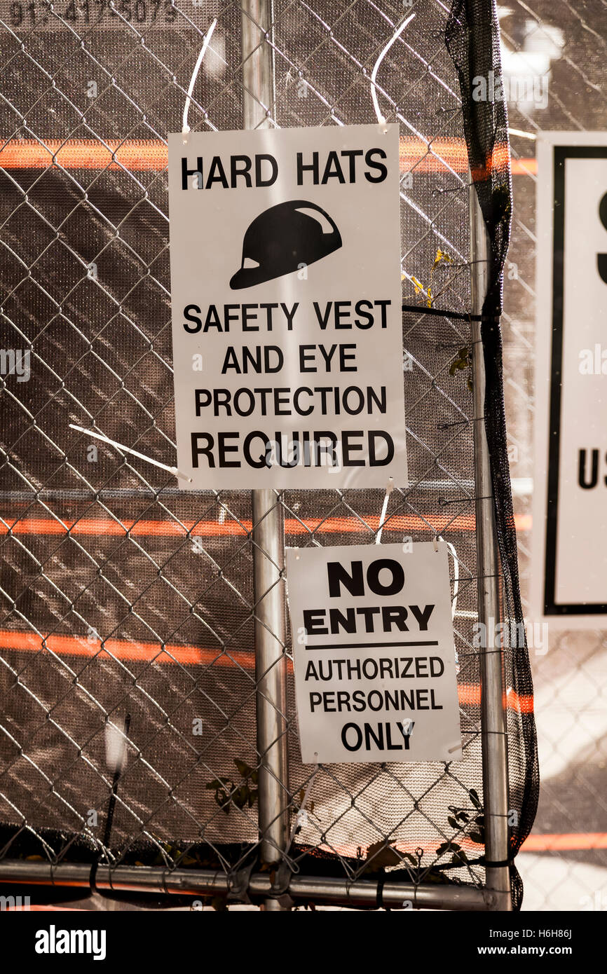 Various warning signs on the fence of a construction site Stock Photo ...