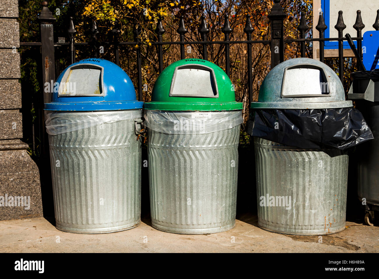Two garbage bins in a park, one for paper, one for cans and one for ...