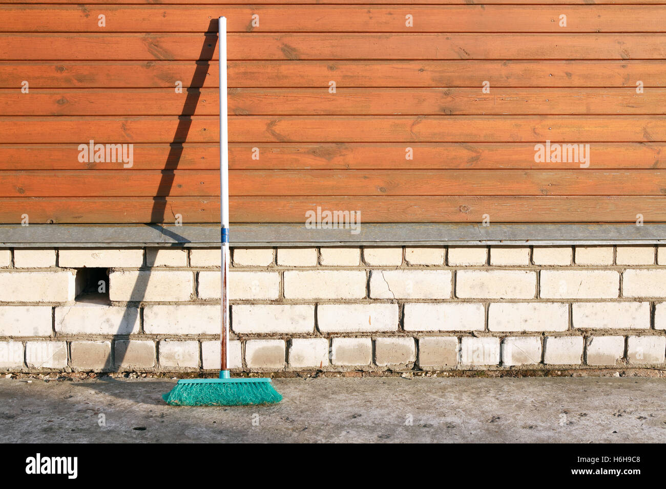 Old mop near wooden wall of house with shadow Stock Photo - Alamy
