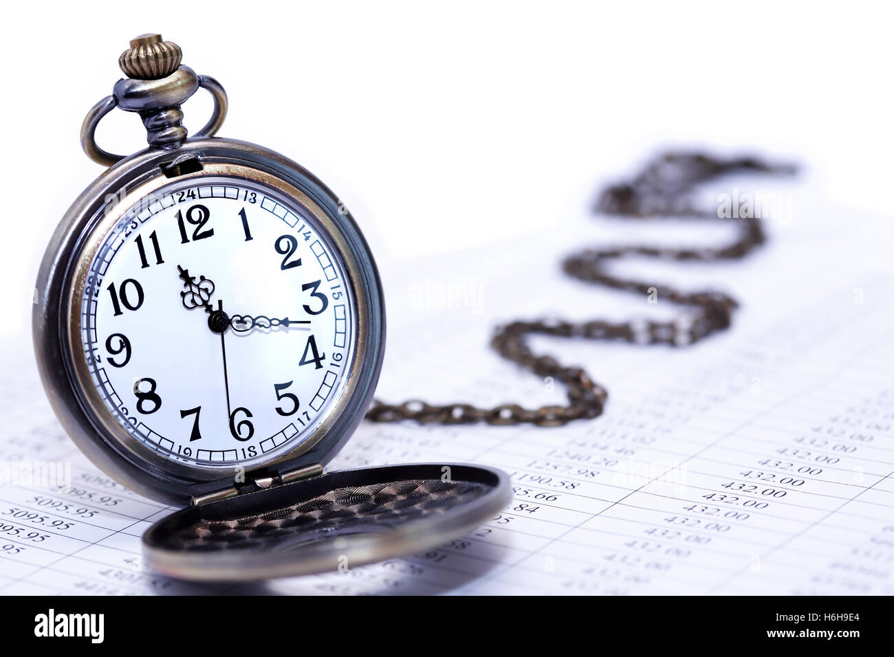 Business concept. Pocket watch with chain on paper table with digits ...
