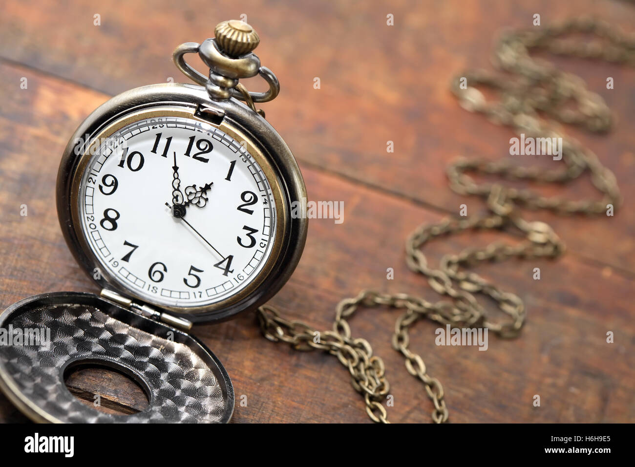 Vintage pocket watch with chain on wooden background Stock Photo - Alamy