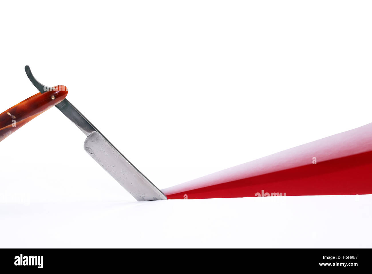 Violence concept. Old straight razor cutting white paper with red ...