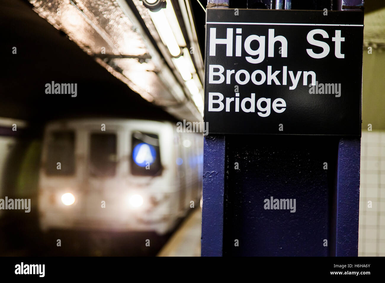 Subway train approaching behind the sign depicting it's the High St ...
