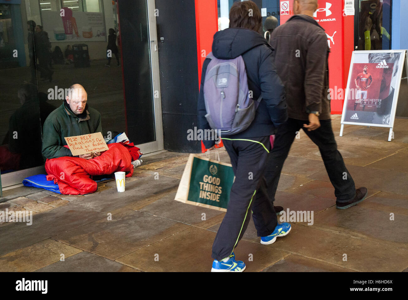 Homeless man sitting on the pavement in Market Square, Manchester, UK ...