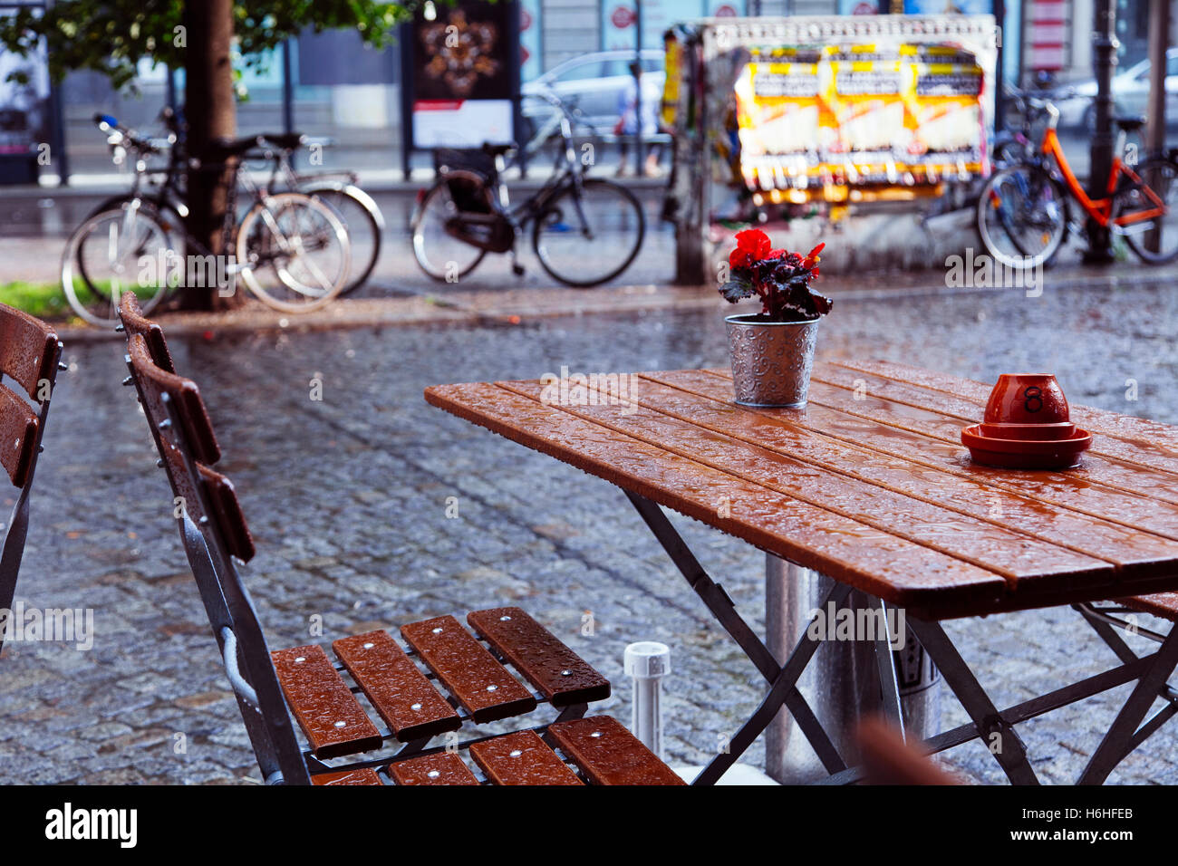 BERLIN - JUNE 18: Wet cafe table and chairs on a rainy day on June 18 ...