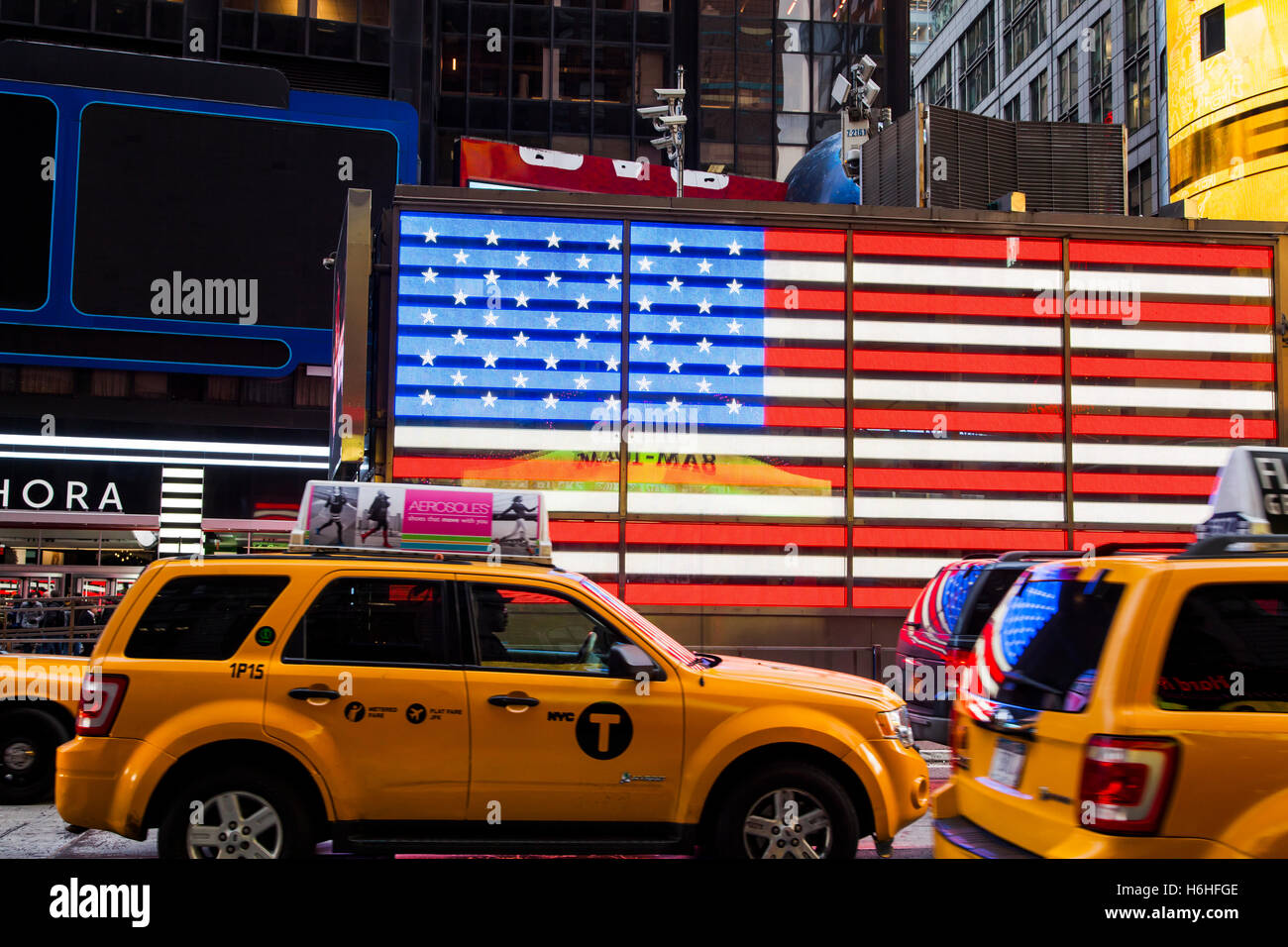 New-York, USA - NOV 20: Taxi cars driving next to the giant LED USA ...