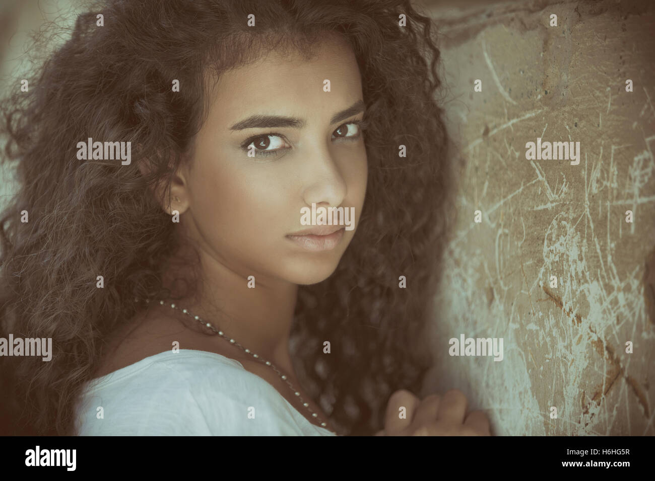 Beautiful young woman leaning against the wall outdoors Stock Photo - Alamy