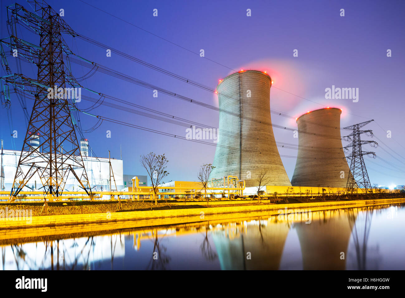 buildings of modern power station near river at twilight Stock Photo ...