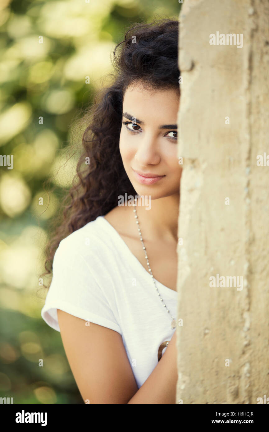Beautiful girl leaning against the wall smiling Stock Photo - Alamy