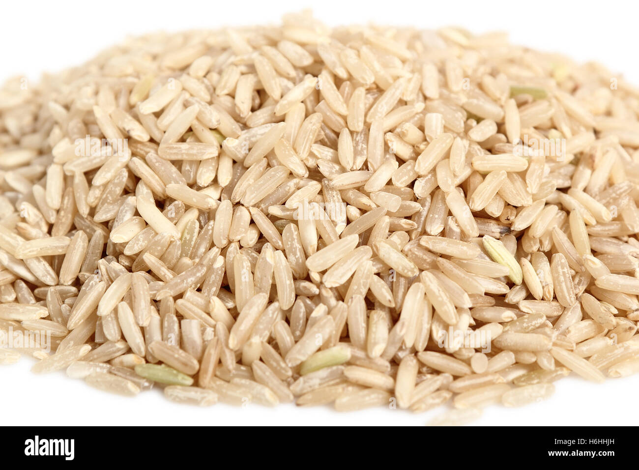 Pile of long grain brown rice. Isolated on white background. Macro ...