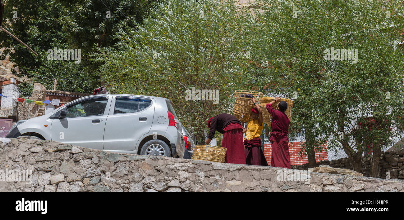 Three monks carying baskets on the approach to Hemis Monastary Stock ...