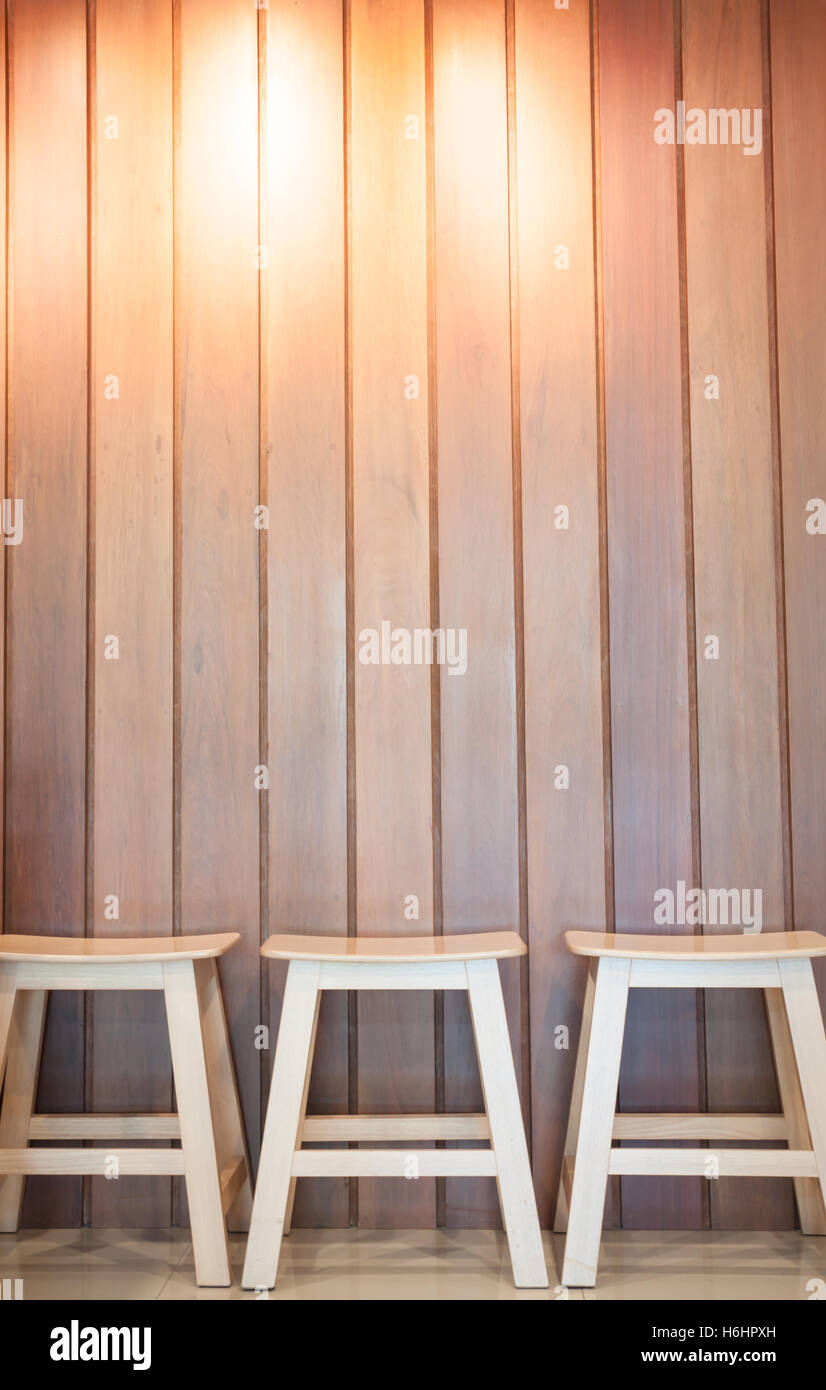 Three wooden chairs on wall background, stock photo Stock Photo - Alamy
