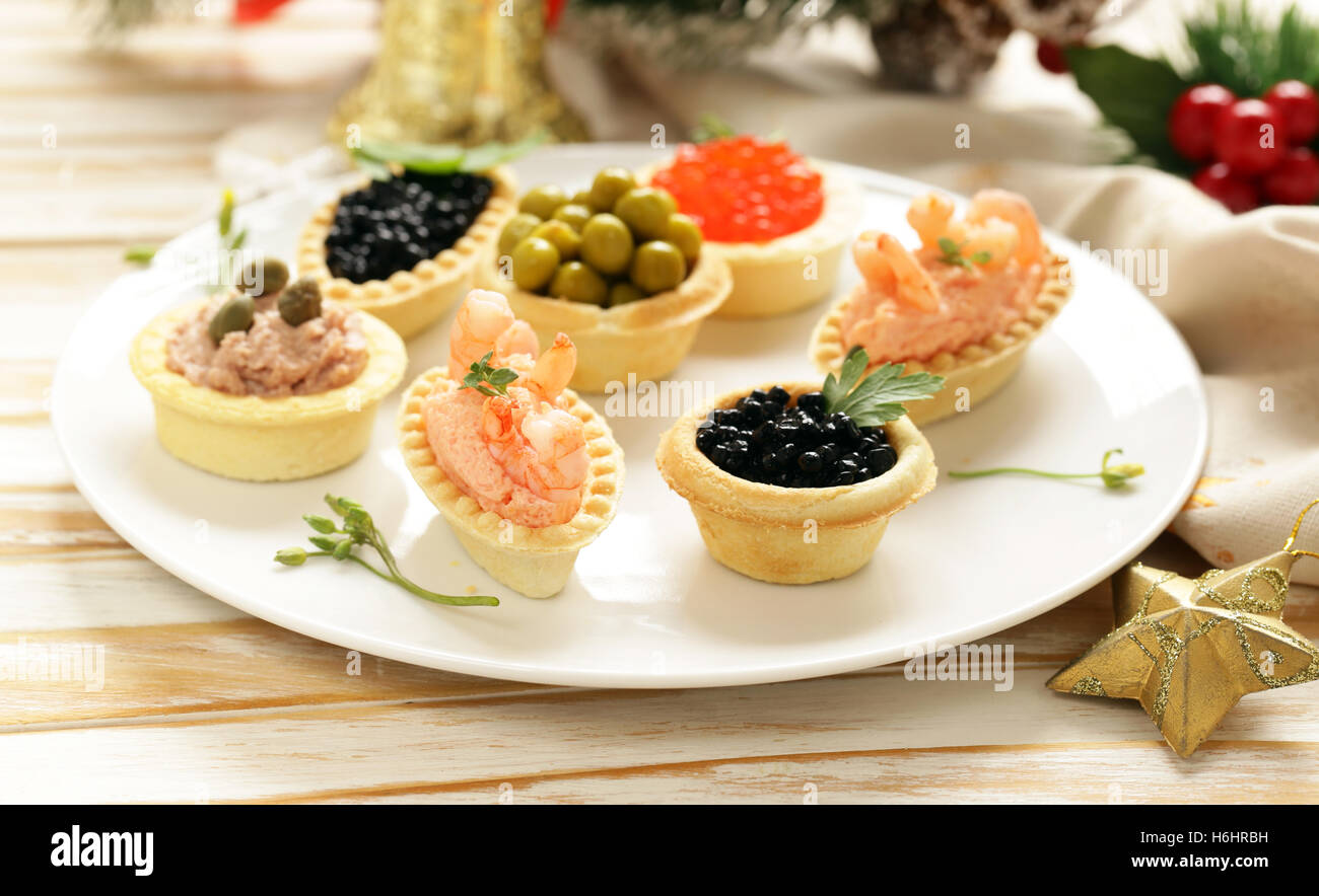 Christmas appetizers. Small tartlets with caviar and pate. Buffet and ...