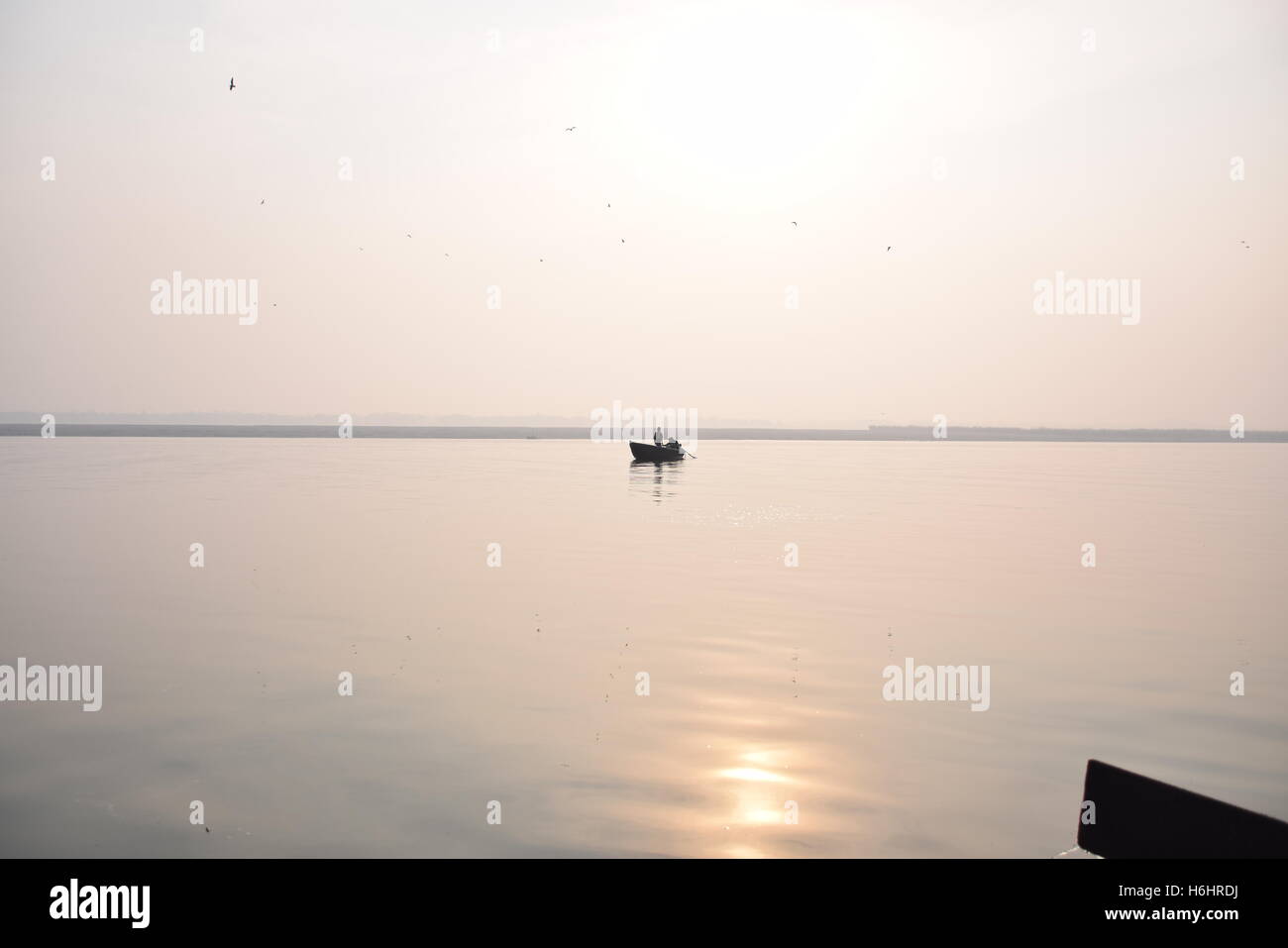 Boat with fishermen floating on river Ganga during sunrise, Varanasi ...