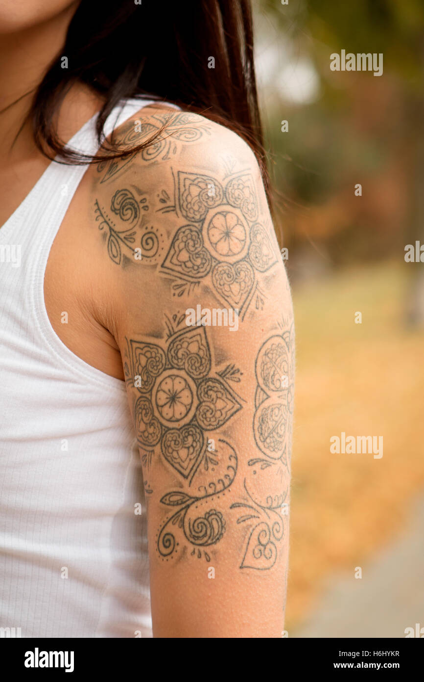Nice arm profile of a brunette woman showing her tattoo Stock Photo - Alamy