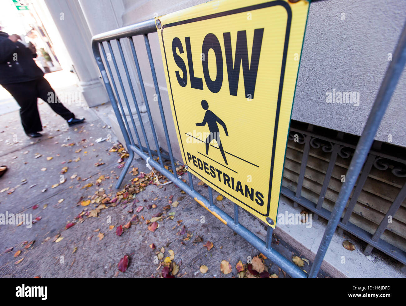 Warning sign saying "Slow - Pedestrians" on a portable barrier in the ...