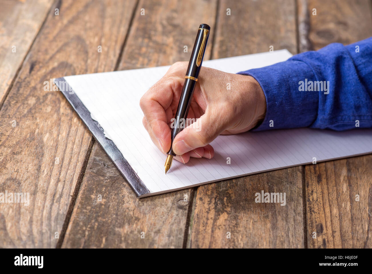 man's hand writing with a fountain pen. wooden background Stock Photo ...