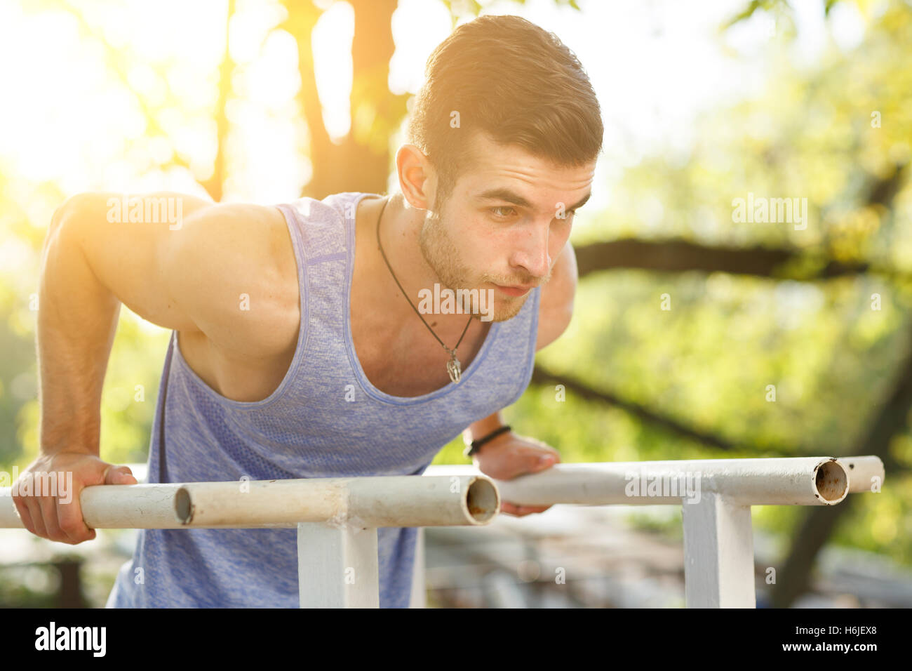 Fitness young man training on parallel crossbars Stock Photo - Alamy