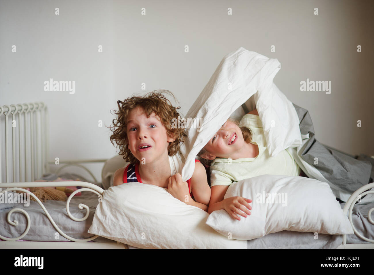 Two children, brother and sister, indulge on the bed in the bedroom ...